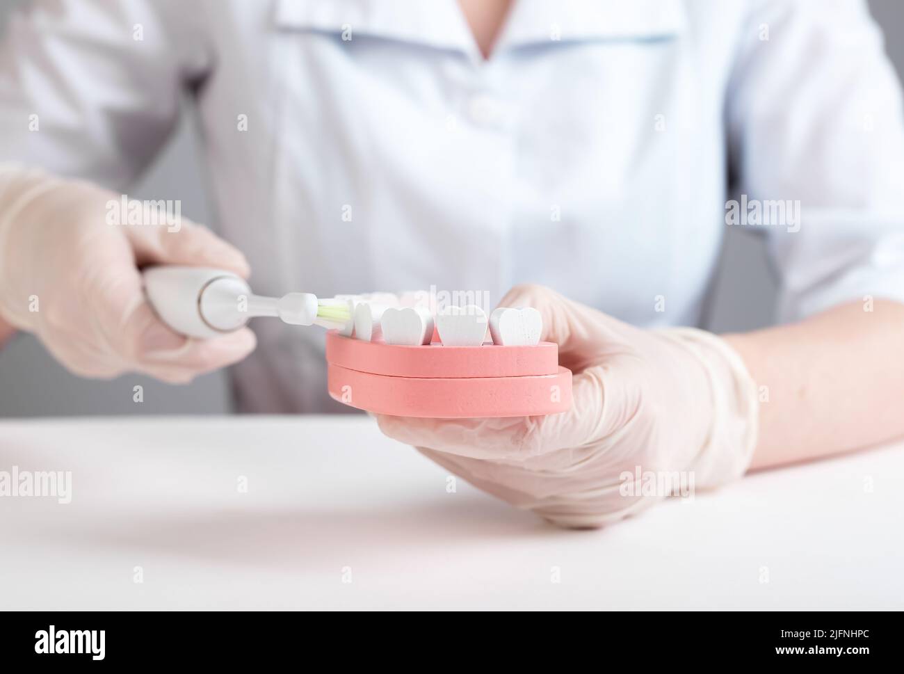 Brushing teeth on toy jaw model with electric toothbrush. Oral dental ...