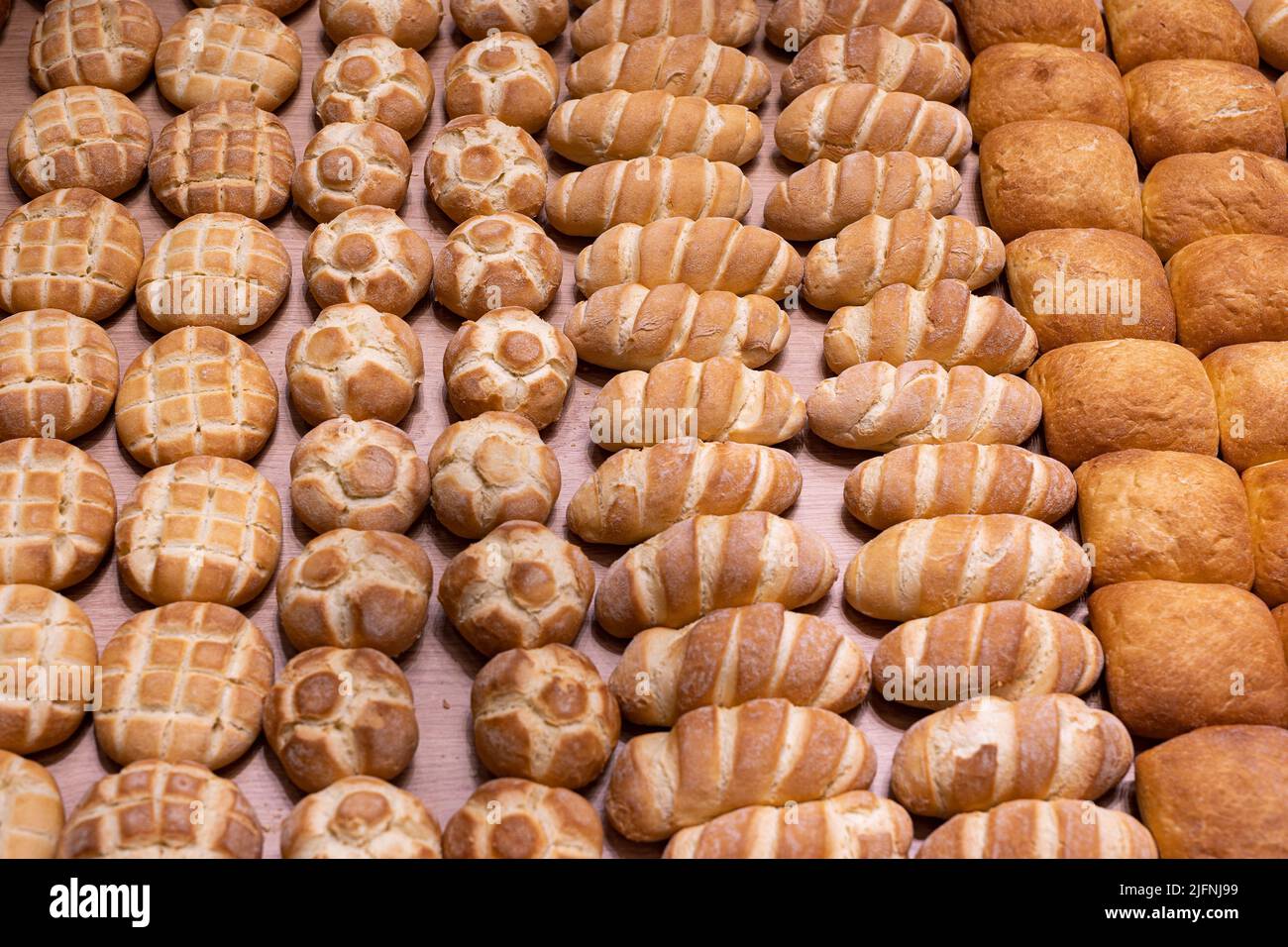 Various Types of Bread Buns displayed Orderly on Top of a Wooden ...
