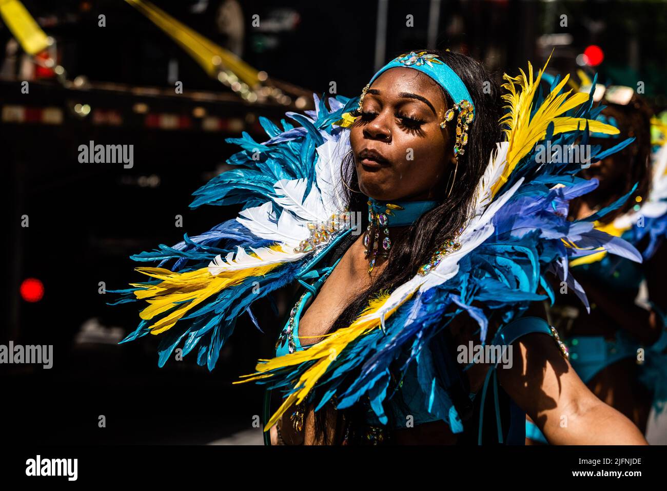A parade dancer wearing a traditional Carnival costume follows the main ...