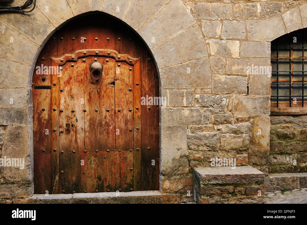 Old arched wooden door. Traditional architecture. Aínsa is the main ...