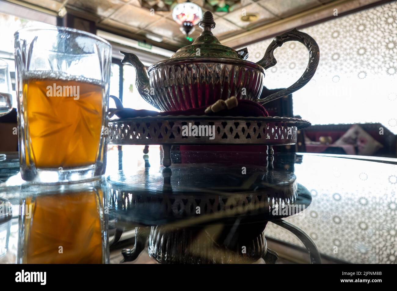 Tea glass next to an Arabic style teapot Stock Photo - Alamy