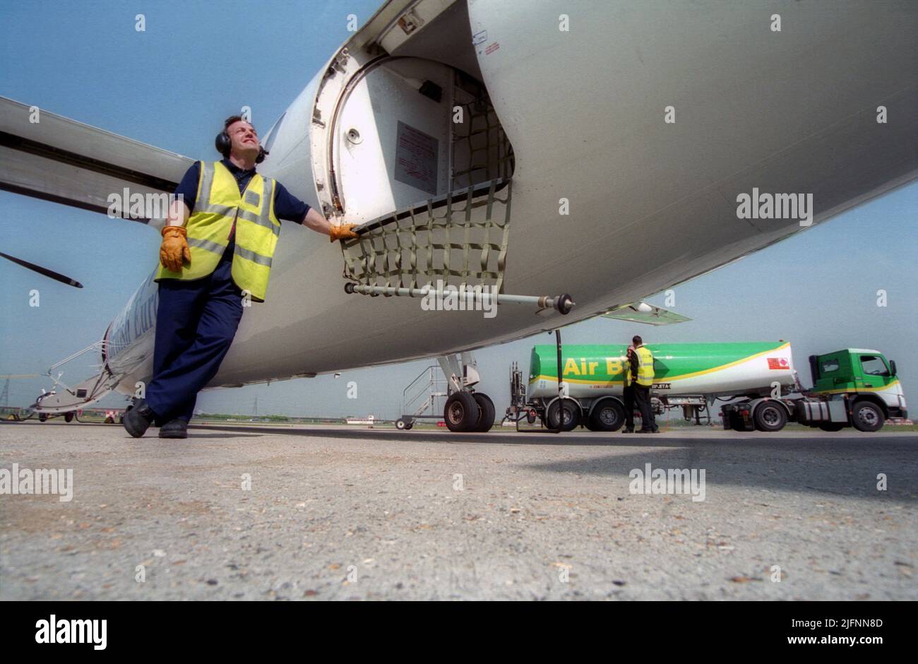 Airport luggage handlers unloading and transporting airline passengers ...