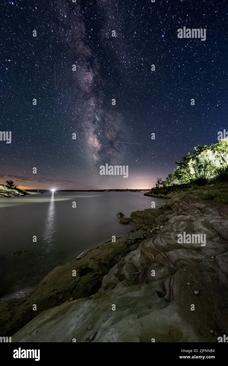 The vertical shore view of the sea against the milky way sky at night ...