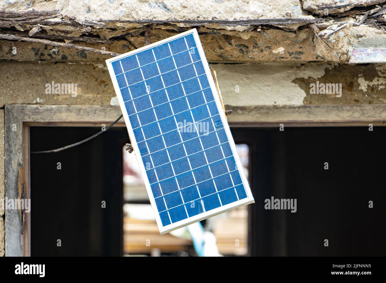 A solar panel hangs in the window of an old unmaintained building Stock ...