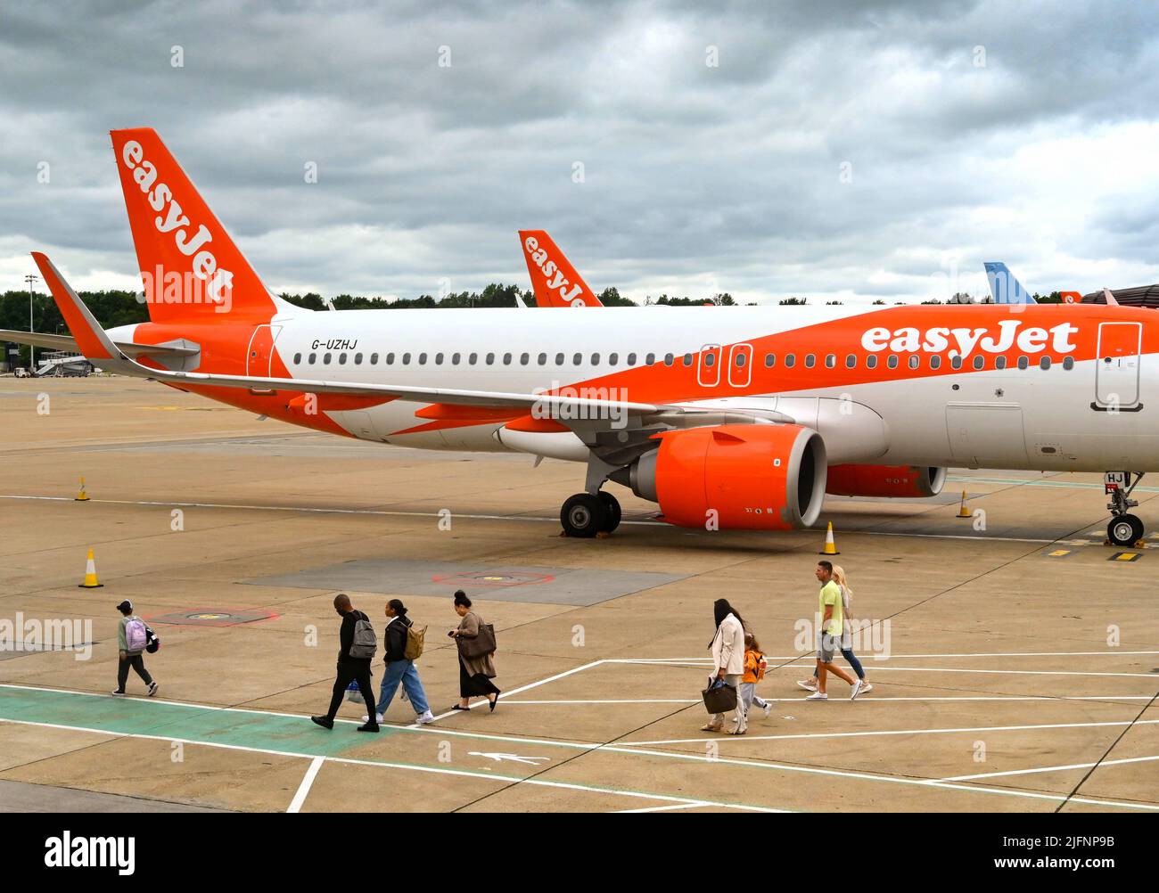 London, England - May 2022: Pasengers walking past an Easyjet Airbus ...