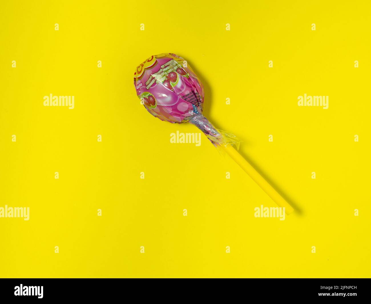 lollipop on a yellow background. Caramel on a stick. Not healthy food ...