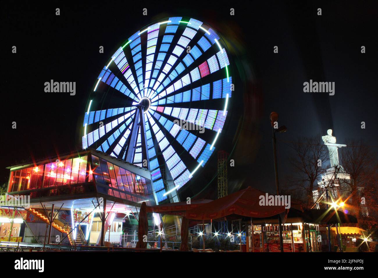 A ferris wheel and Mother Armenia monument in Victory Park at night ...