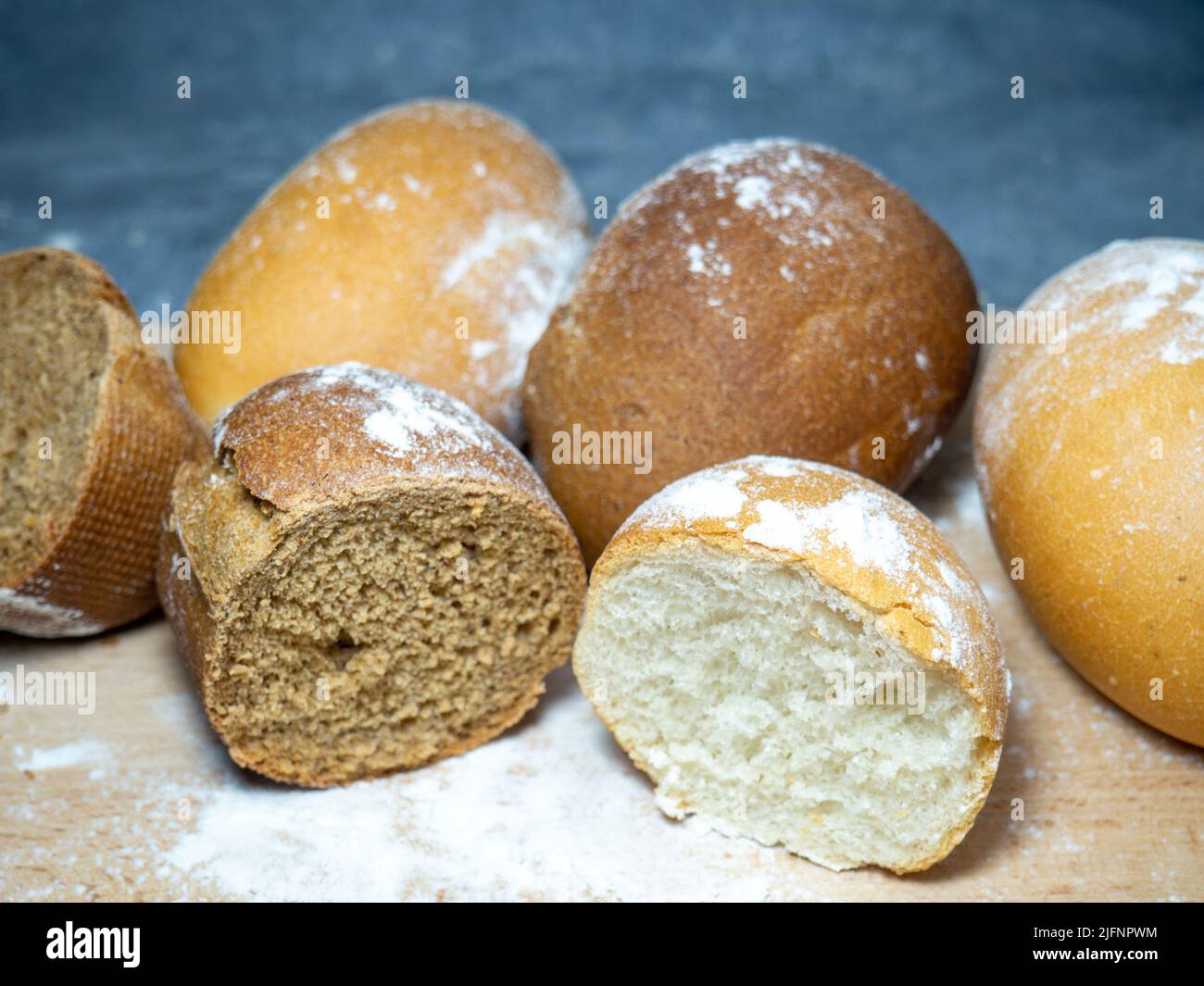 Bakery products. Table in the bakery. Buns on a cutting board. Rye and ...