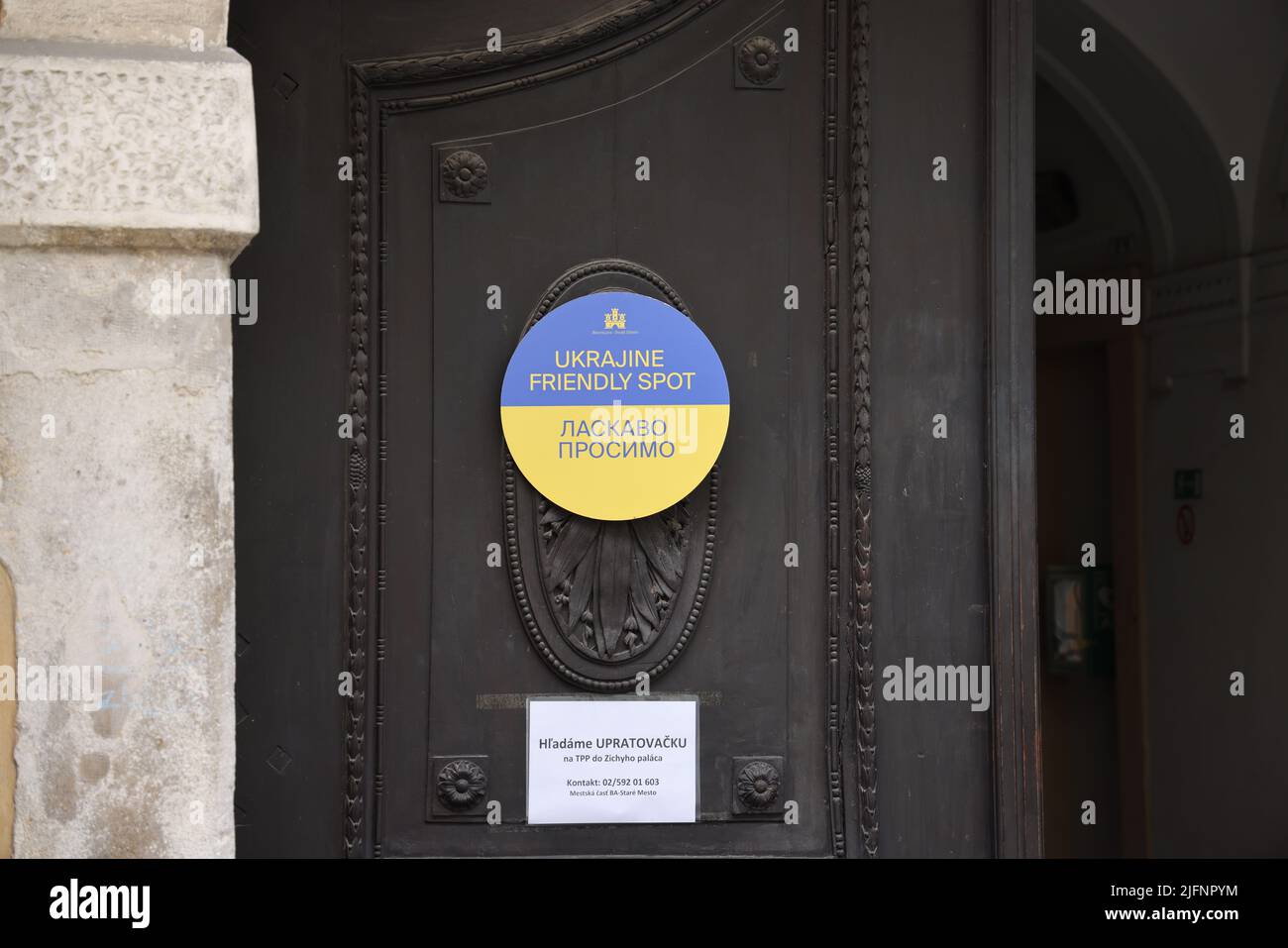 Doors with yellow-blue sign with text "Ukrajine friendly spot - Ласкаво ...