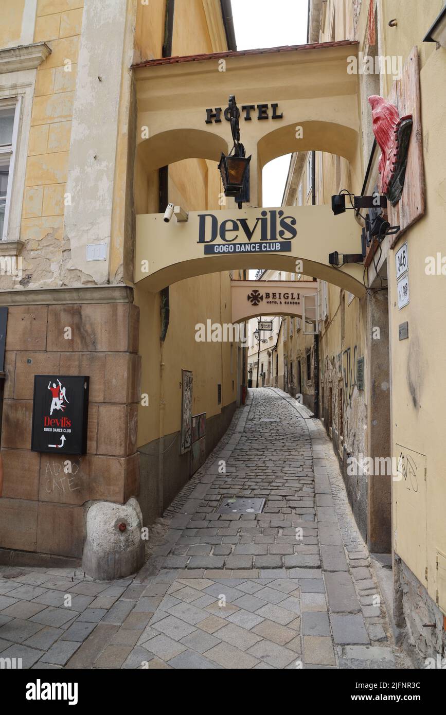 Arch over narrow old cobblestone street with text "Devil's Gogo Dance ...