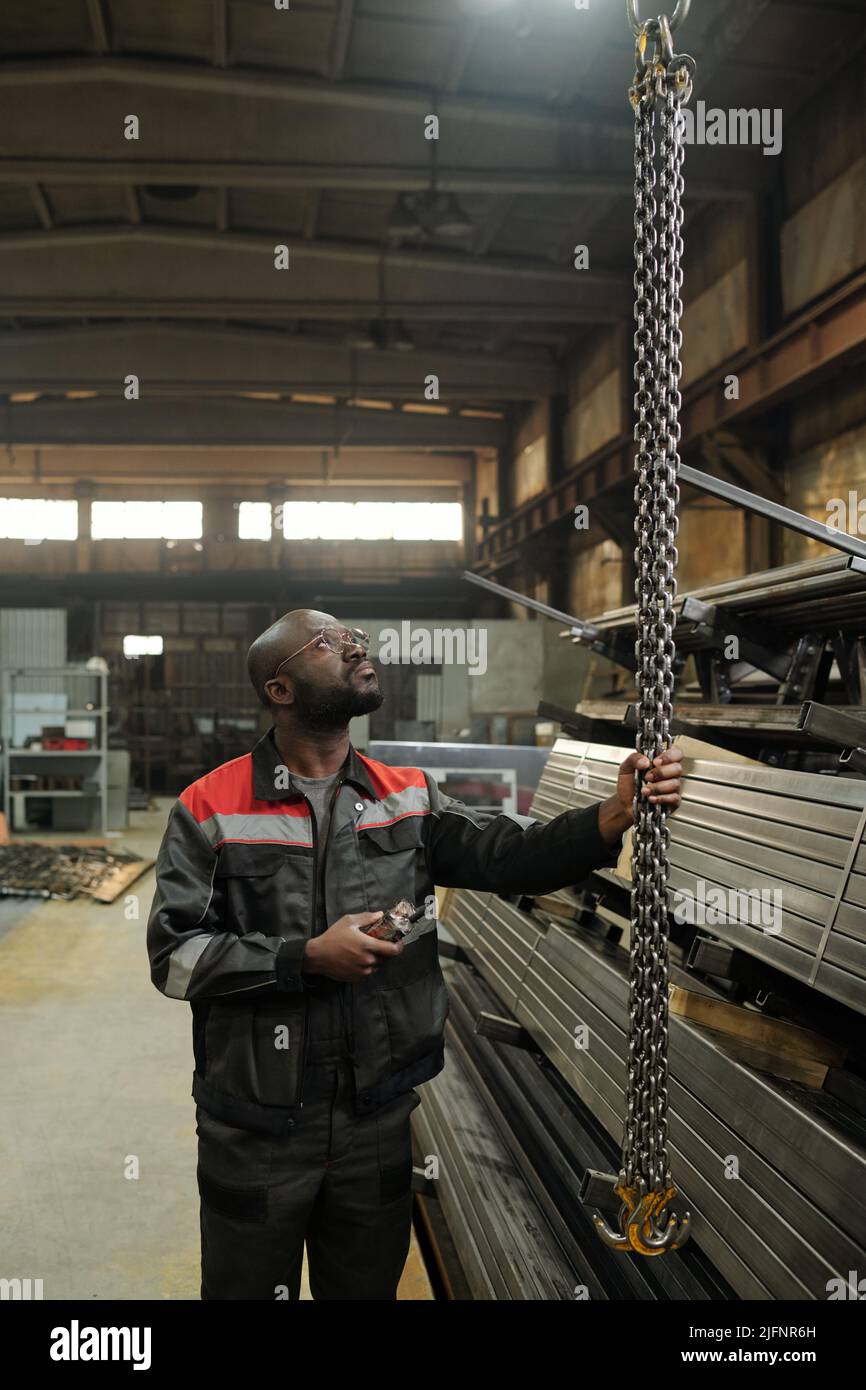 Young African American engineer looking upwards while pulling bunch of ...