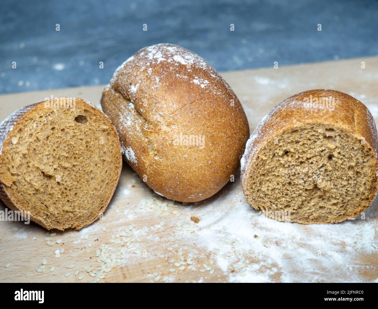 Bakery products. Table in the bakery. Buns on a cutting board. Rye buns ...