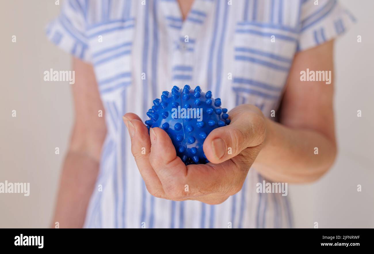Elderly woman squeezing a prickly ball in her hands, massage for ...