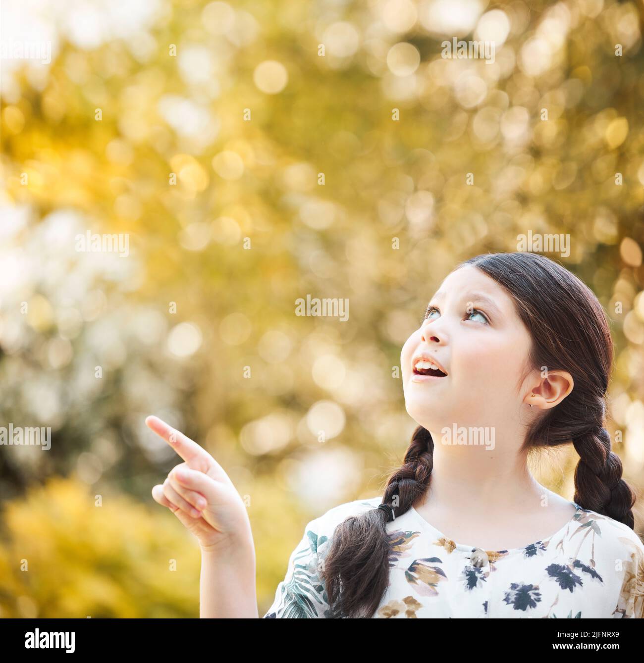 Young caucasian girl pointing in a direction in a forest while smiling ...