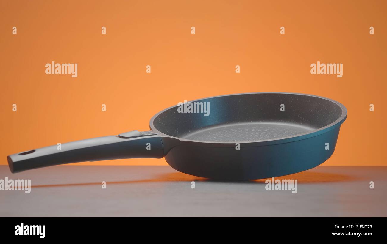 New pan with non-stick coating. Action. Modern stylish coated frying ...