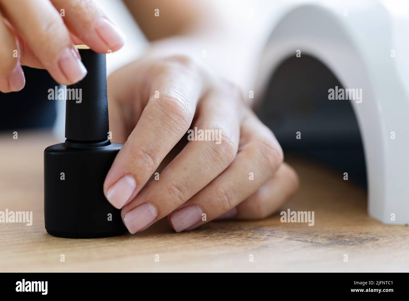 Womans hands holding black bottle of shellac. Manicure concept Stock ...