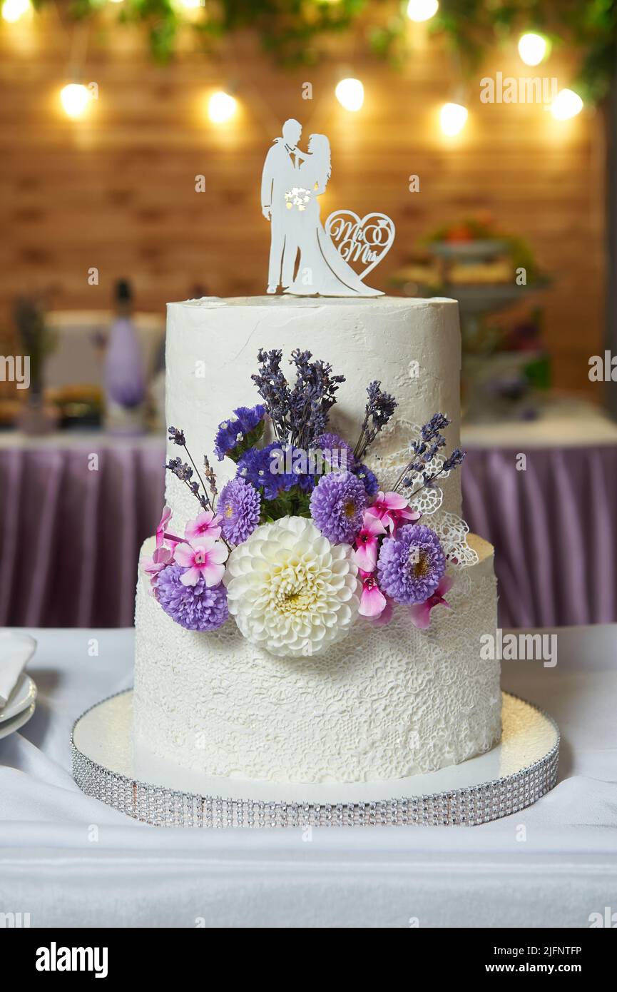 Two-tiered wedding cake with flower decoration Stock Photo - Alamy