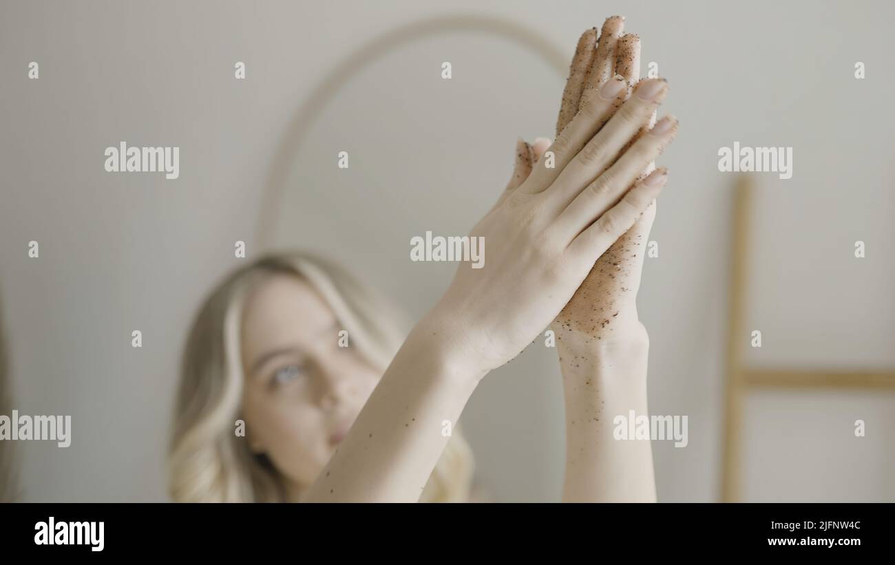 Close-up of attractive woman scrubbing skin. Action. Bright atmosphere ...
