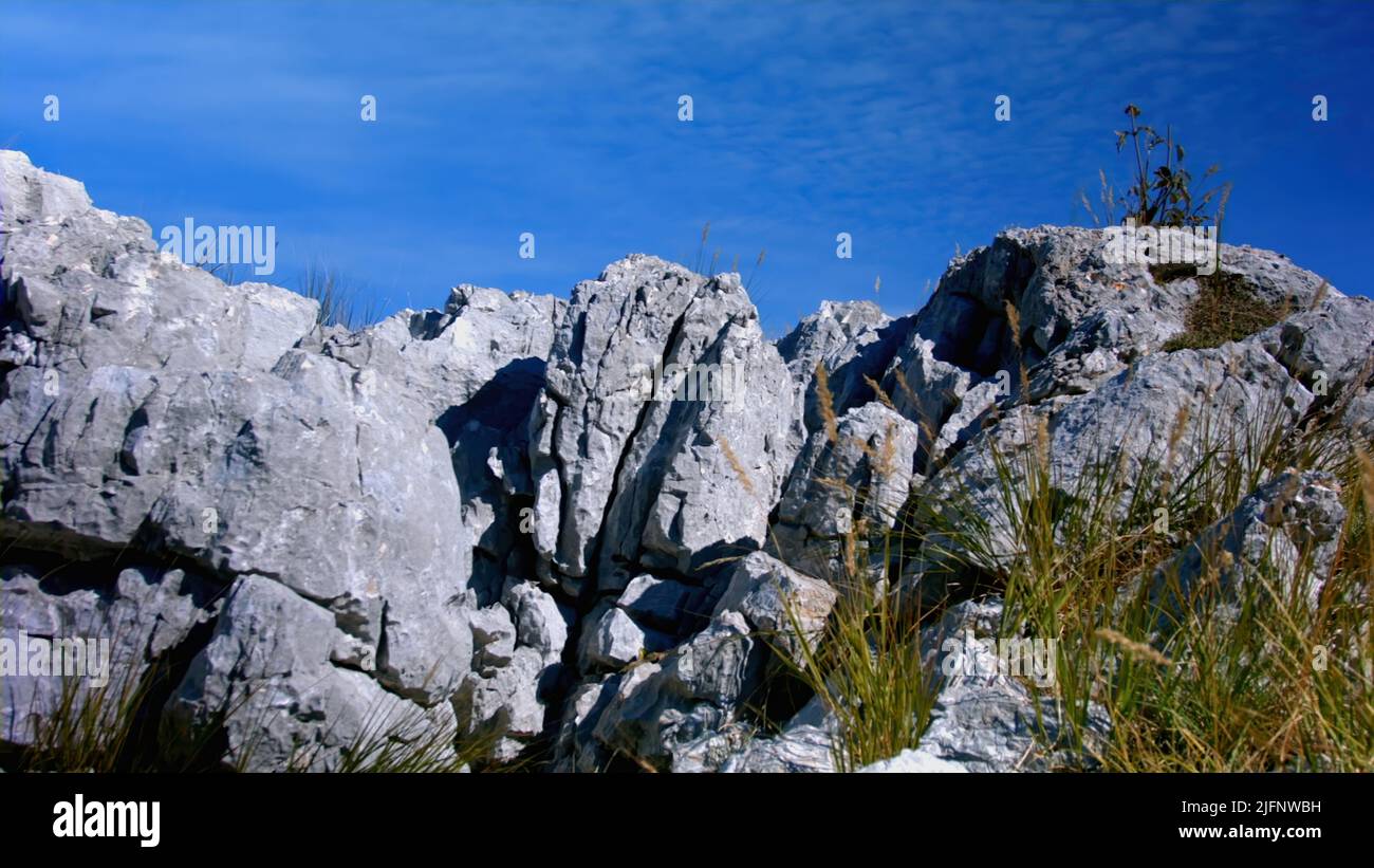 A big stone.Creative.A large stone hill with green grass and a bright ...