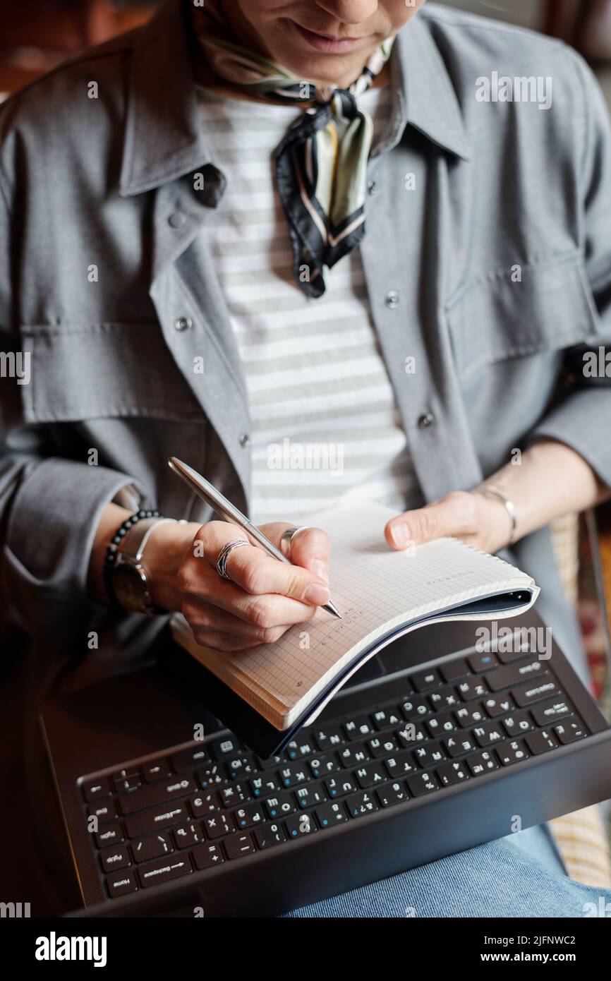 Businesswoman or freelancer with pen over blank page of copybook and ...