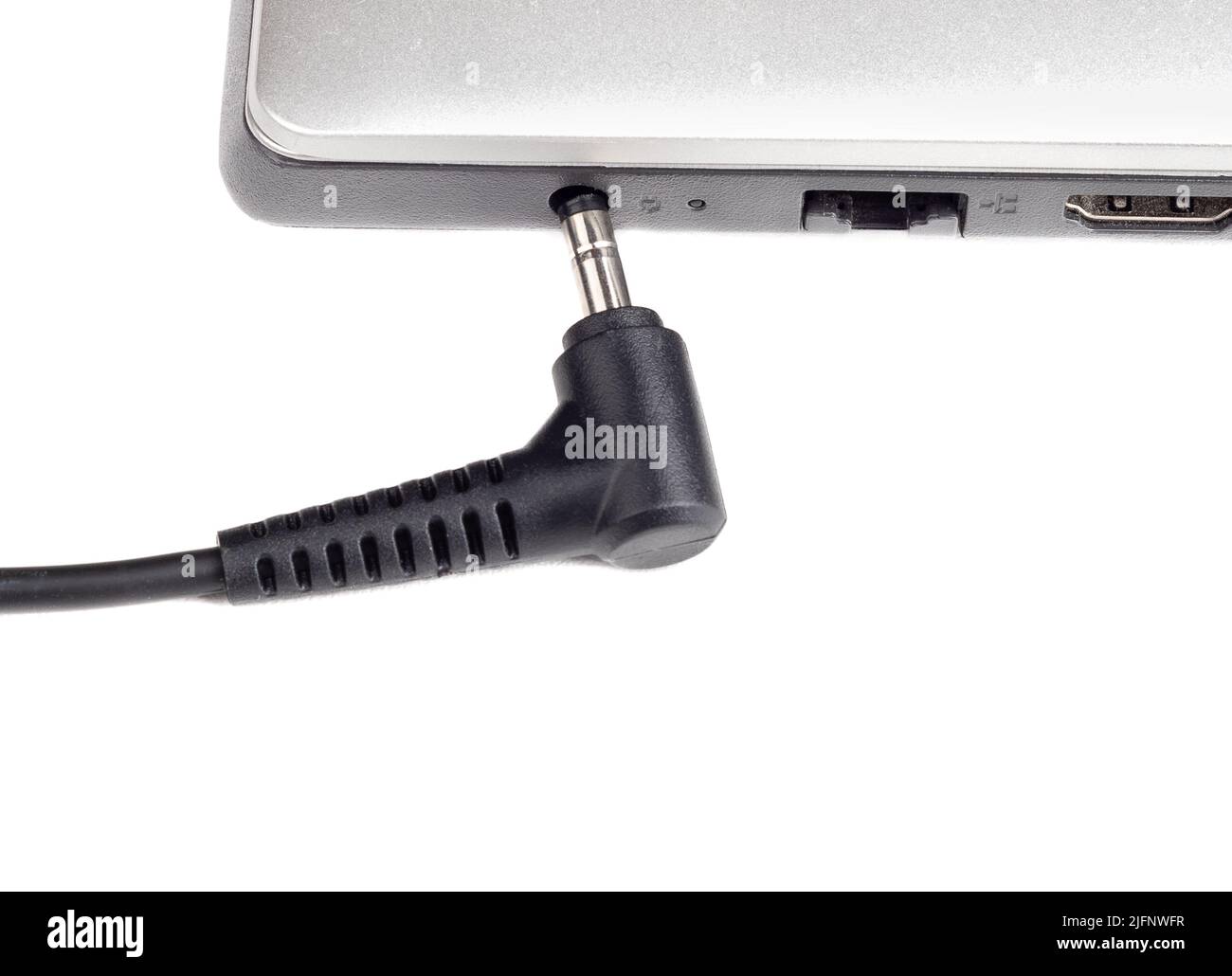 Connecting the power adapter to a laptop on a white background. Copy ...