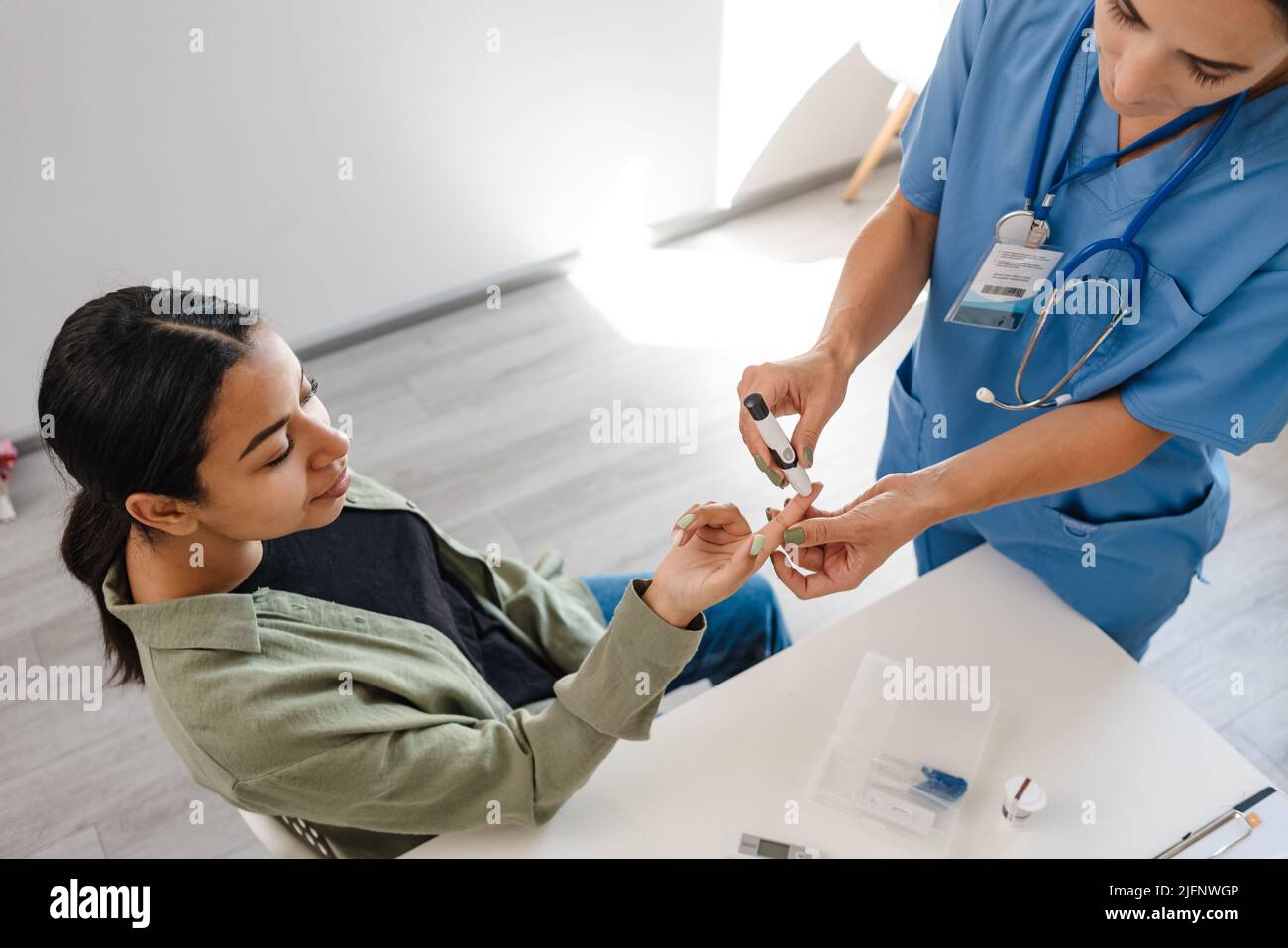White woman doctor measuring glucose while working in her office ...