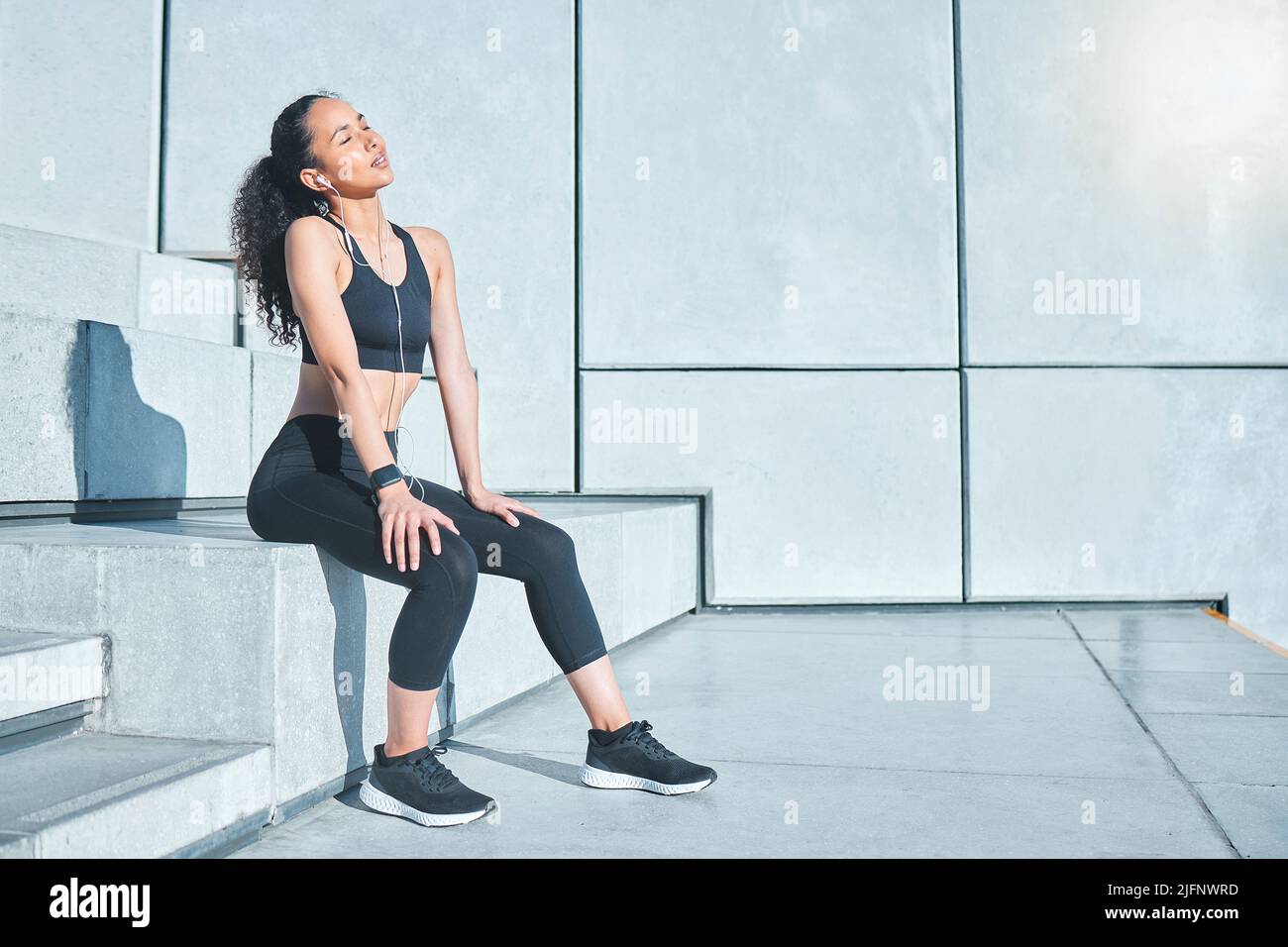 She needed a breather. Full length shot of an attractive young female athlete exercising outside ...
