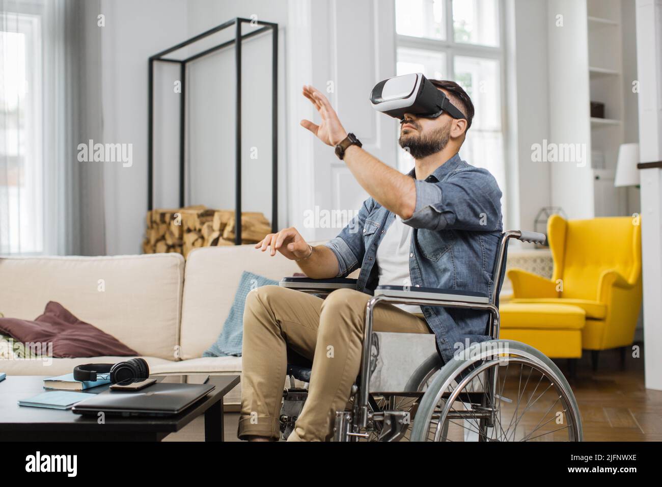 Caucasian man using VR glasses while sitting in wheelchair and playing ...