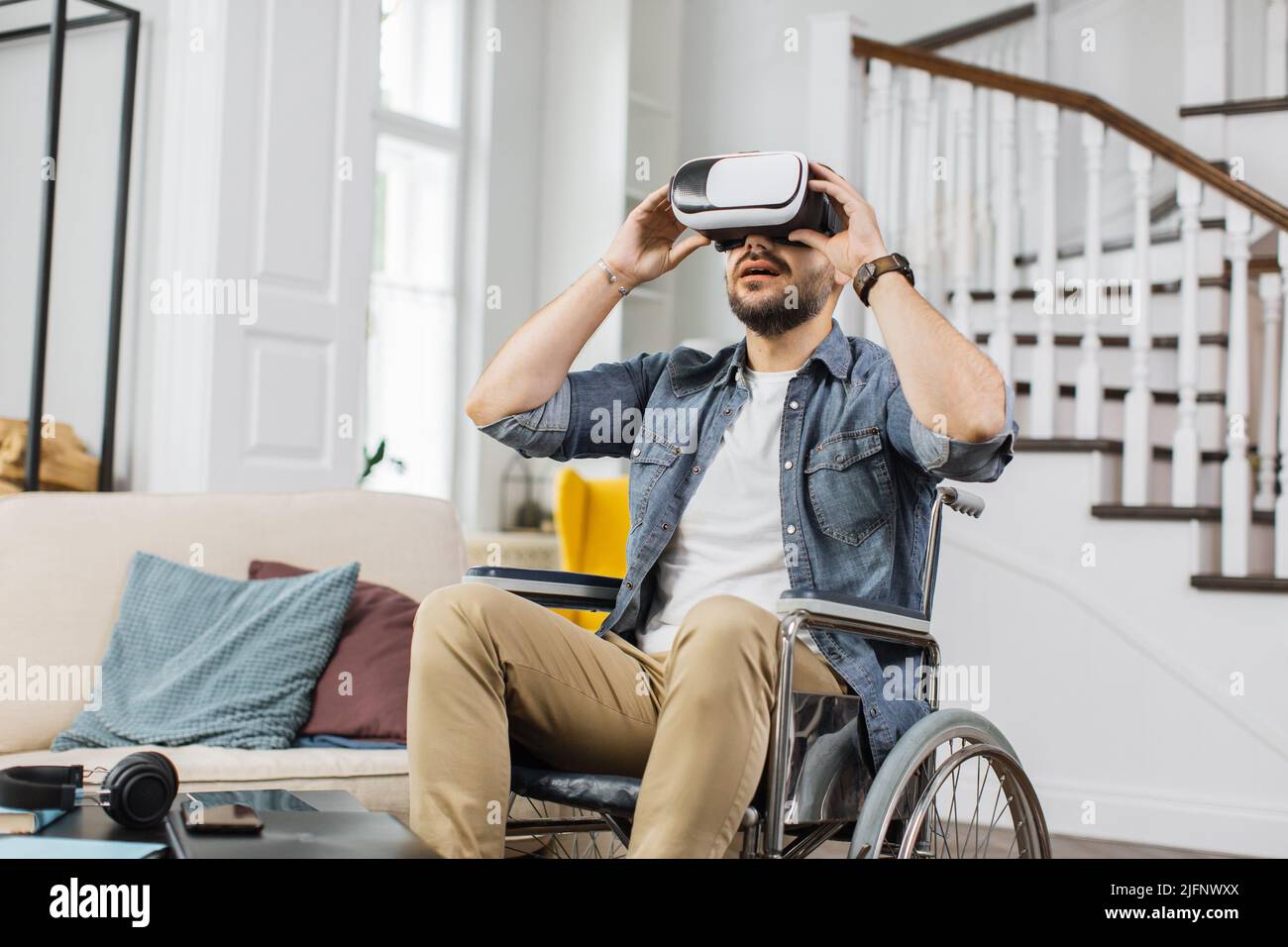 Disabled man watching virtual video using goggles of augmented reality ...