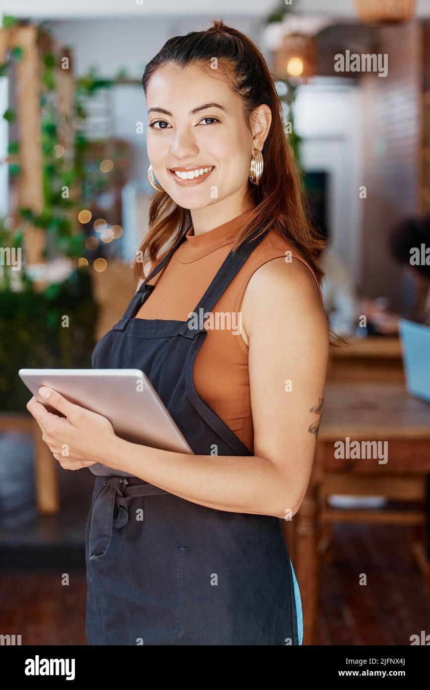 Young hispanic business owner using a wireless tablet in her retail ...