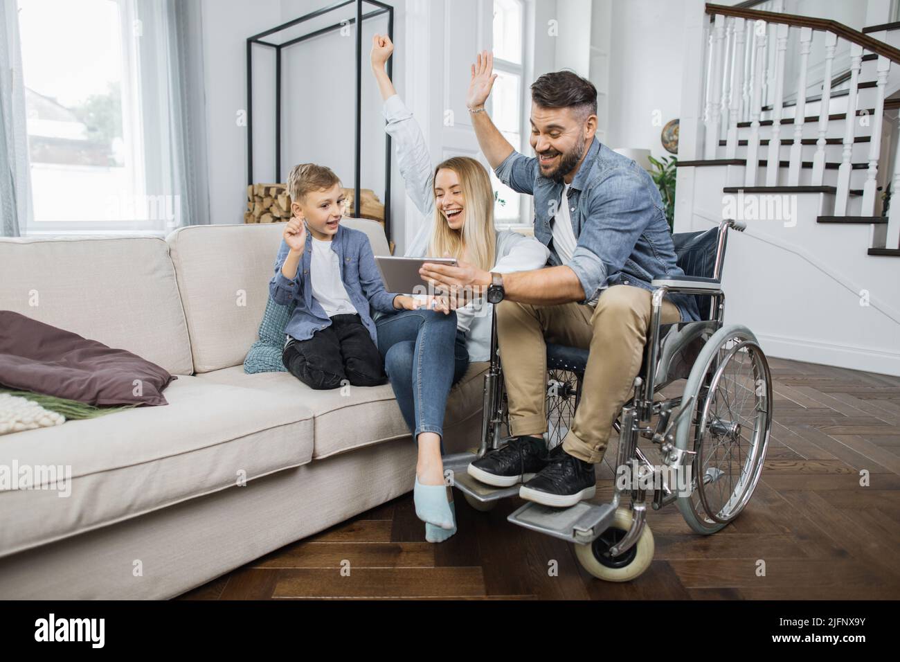 Friendly lovely family of son, mom and disabled dad celebrating victory ...