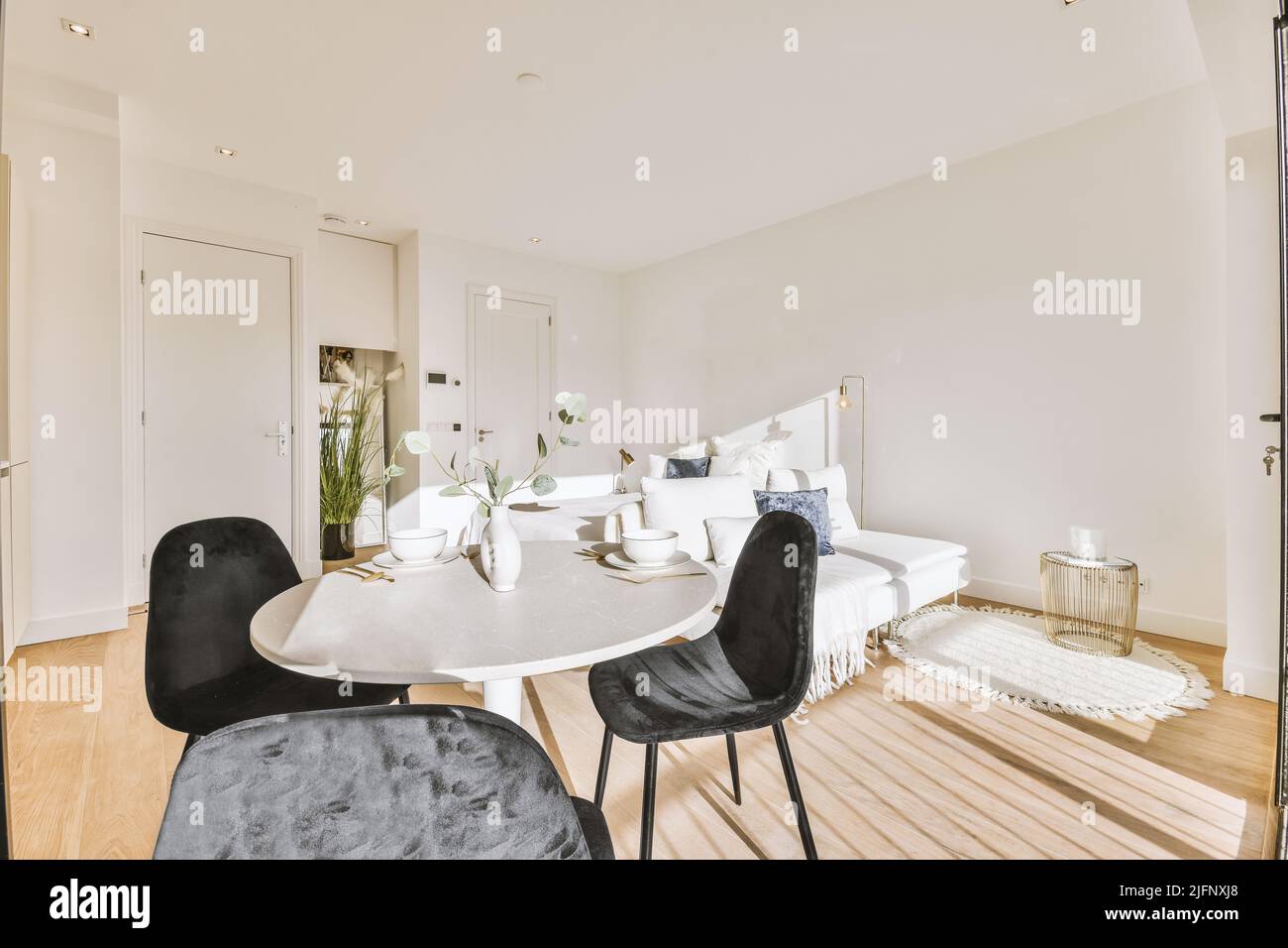 Interior of light room with stylish dining and lounge areas in modern ...