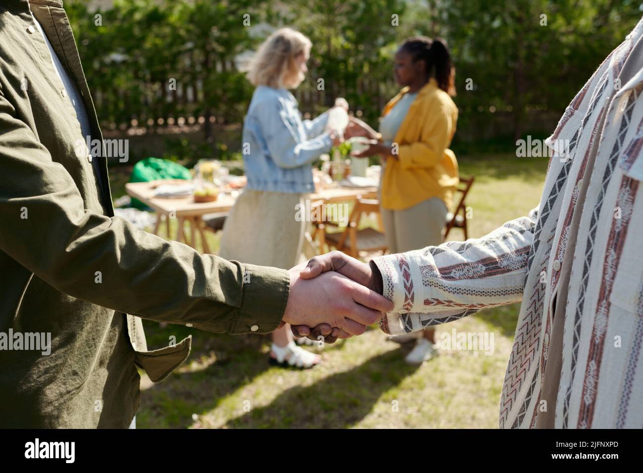 Handshake of two young intercultural men greeting each other against ...