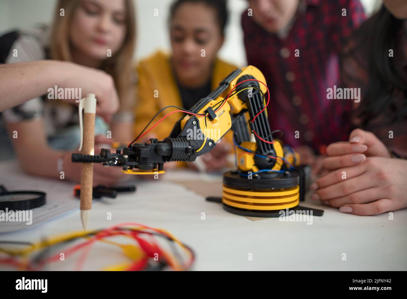Group of students building and programming electric toys and robots at ...
