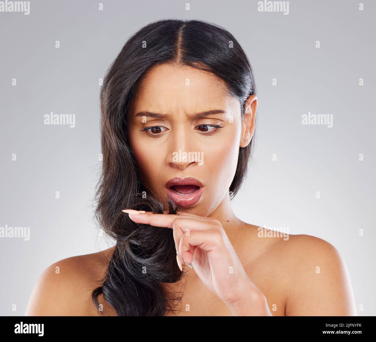 Split ends. Cropped shot of an attractive young woman looking unhappy ...