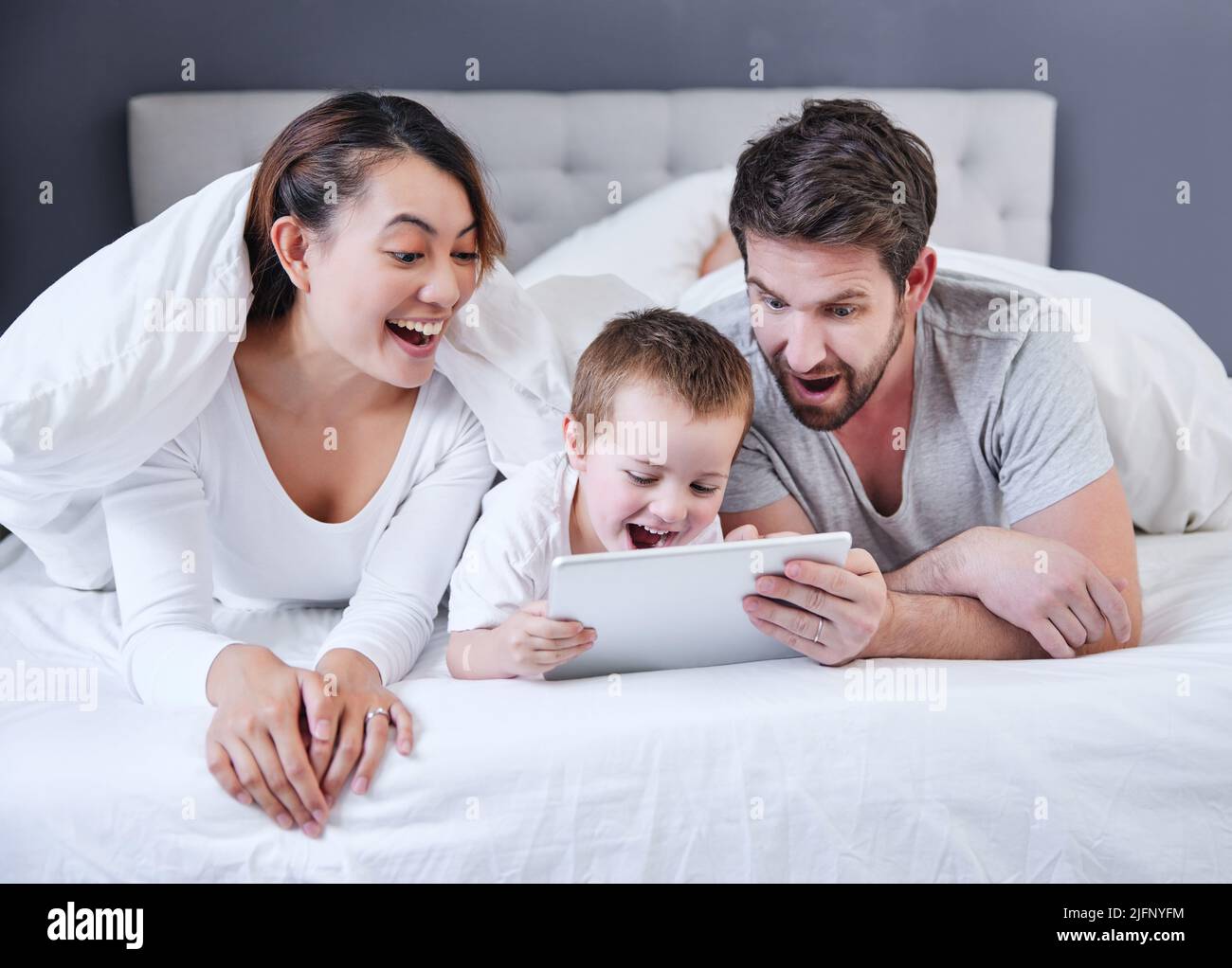 What a great show. Shot of a young family using a digital tablet ...
