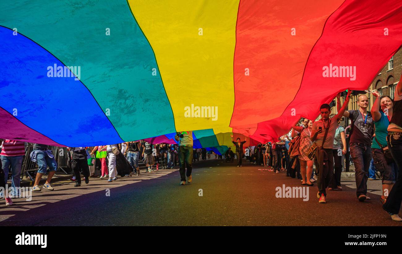 Marching under a giant rainbow flag at Pride In London Stock Photo - Alamy