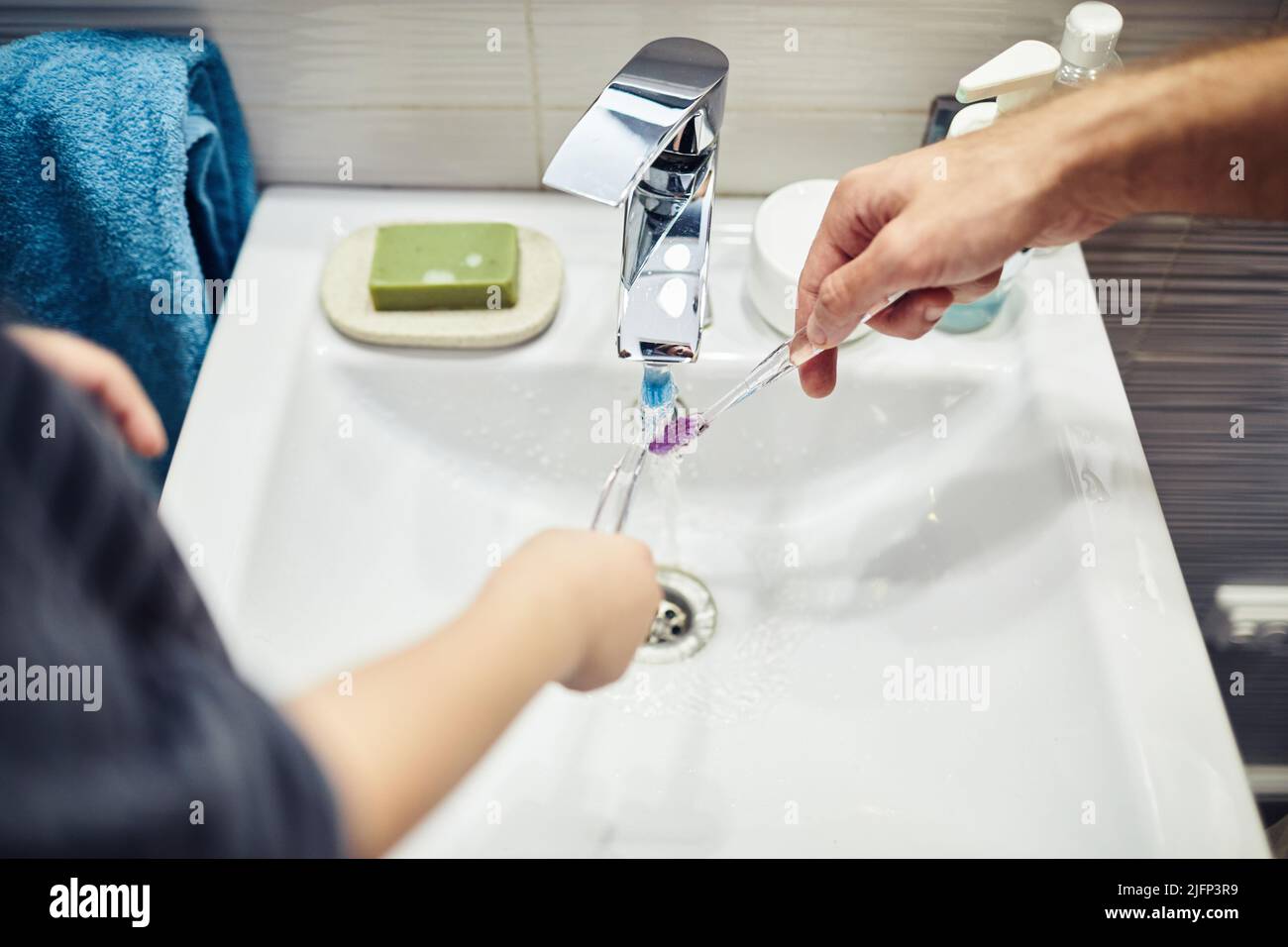Close up of father and son brushing teeth together and washing ...