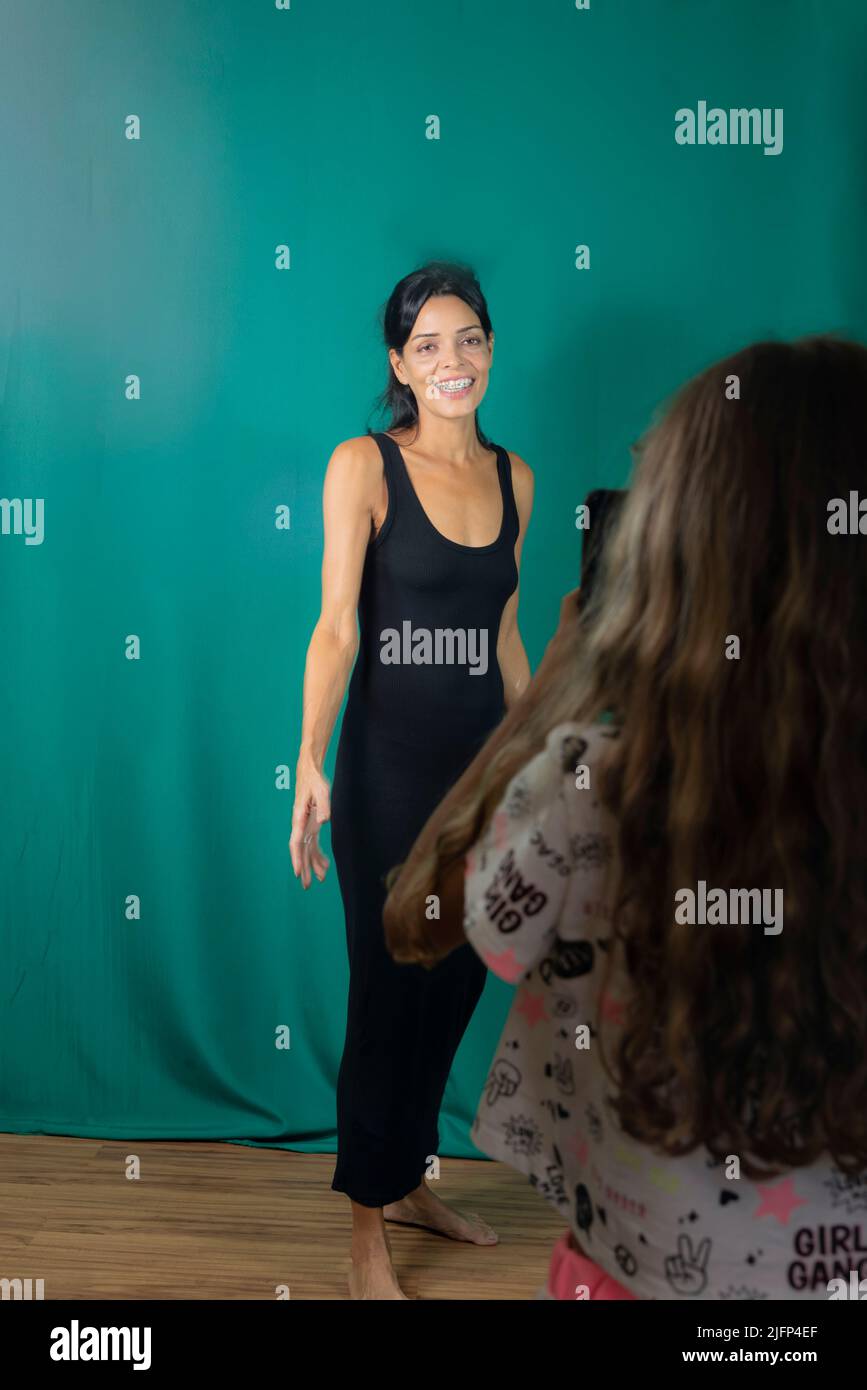 Portrait of standing adult model being photographed by a child against ...