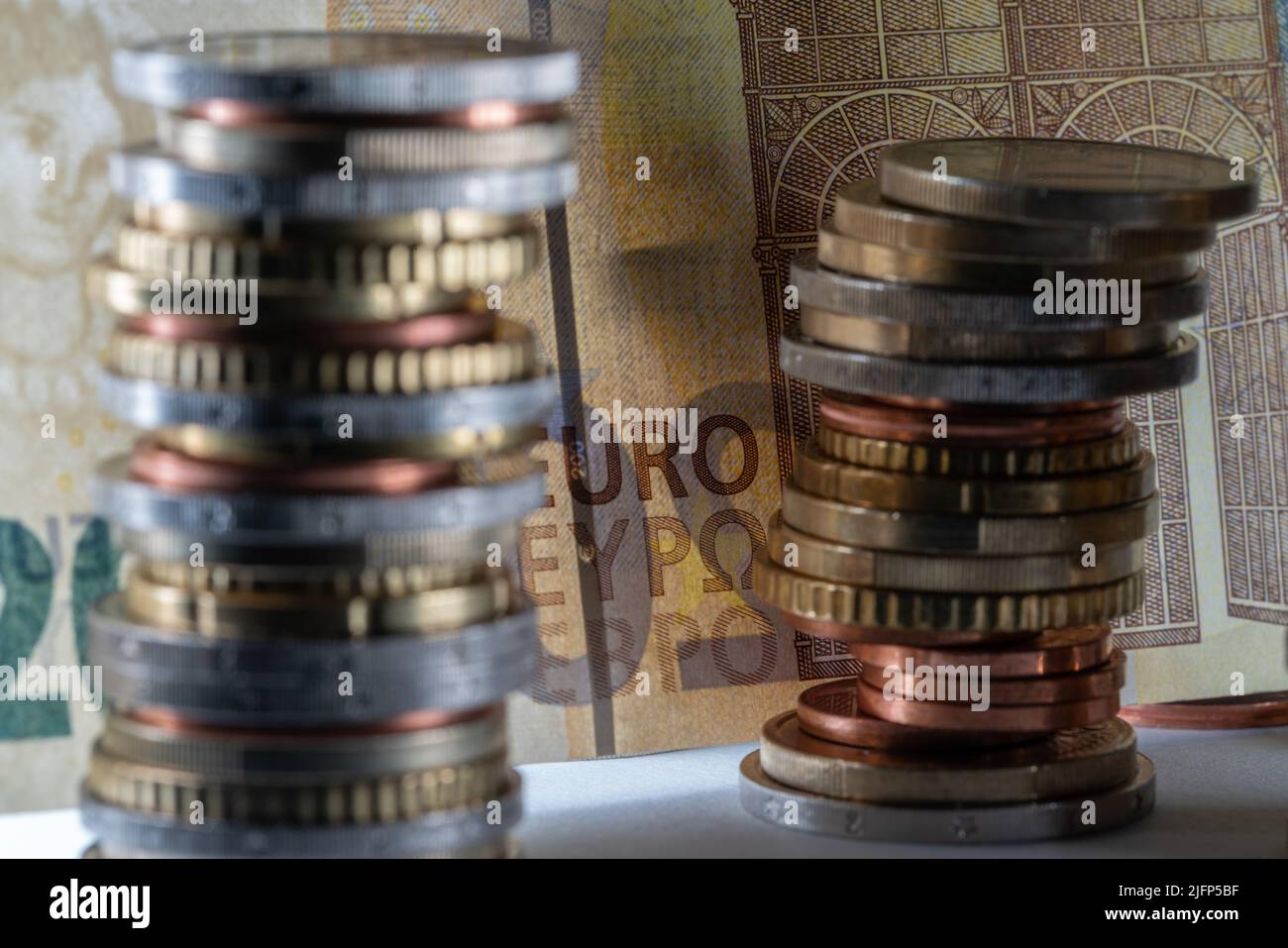 Stacked Euro coins in front of a 200 Euro banknote. EURO writing on ...