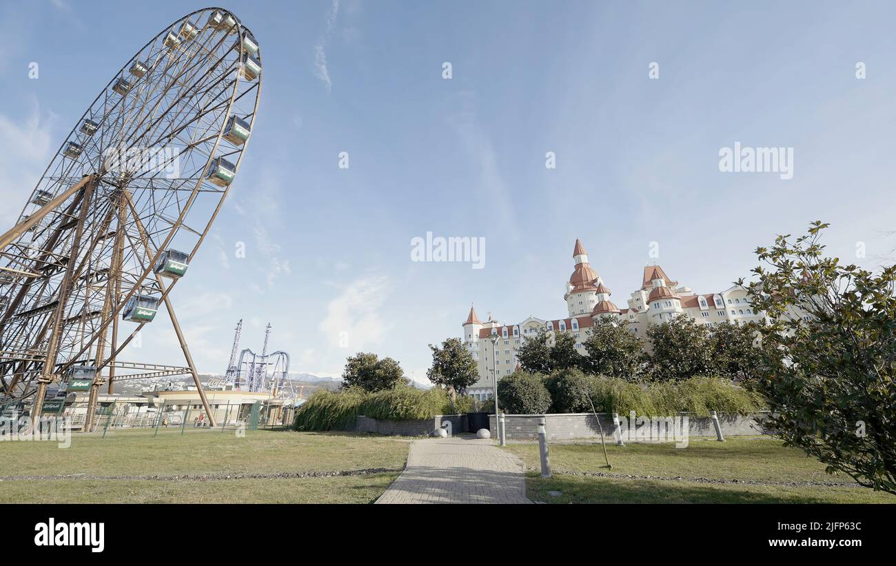A large castle in an amusement park.Action.A large park with a Ferris ...