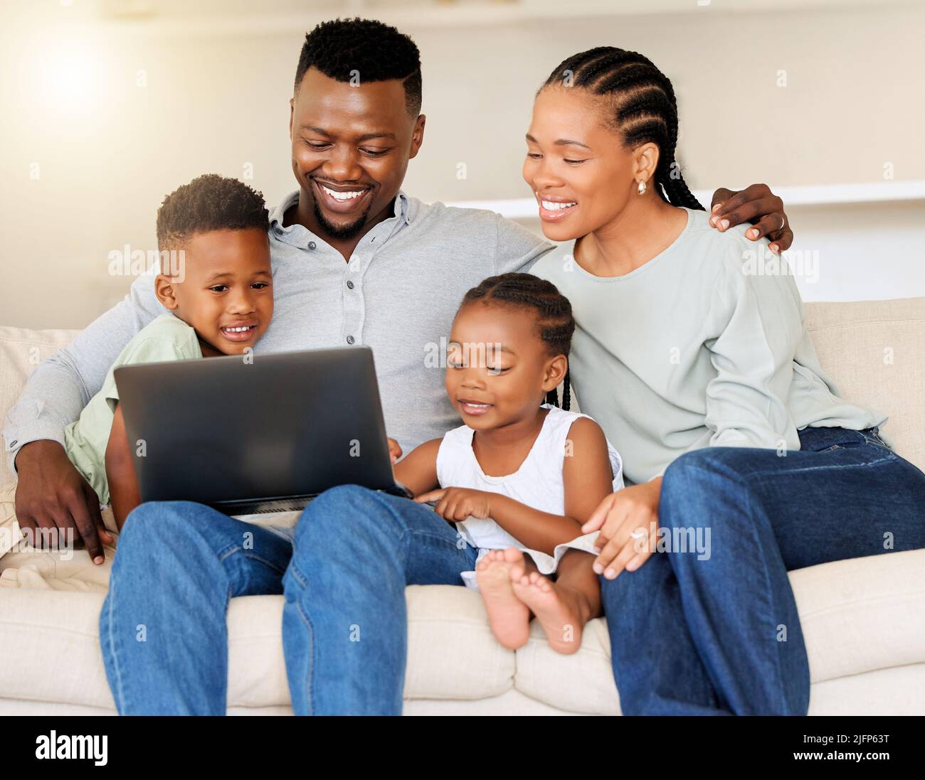 Happy young african american family sitting together and using laptop ...