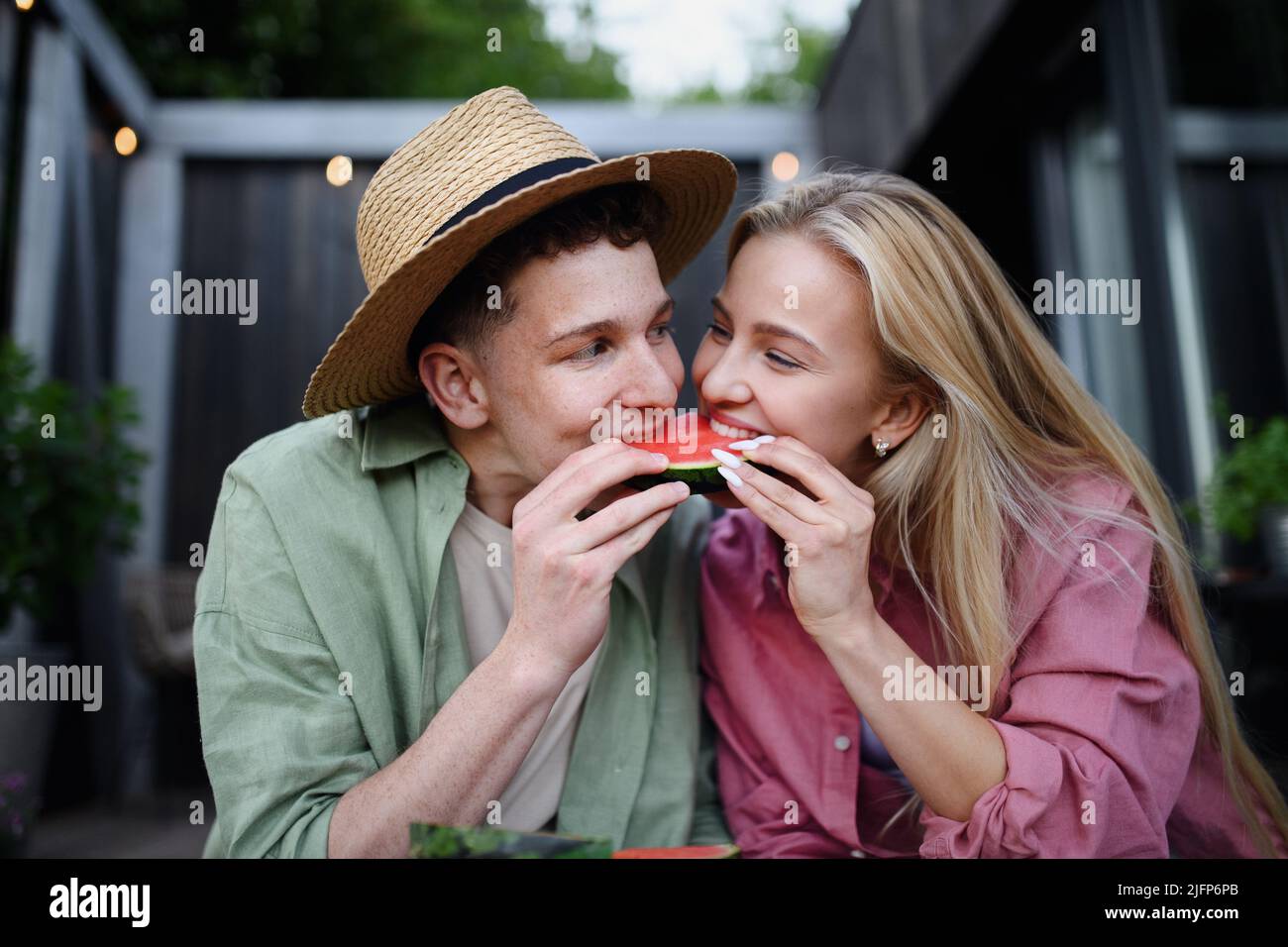 Cheerful young couple in love eating slice of watermelon together Stock ...