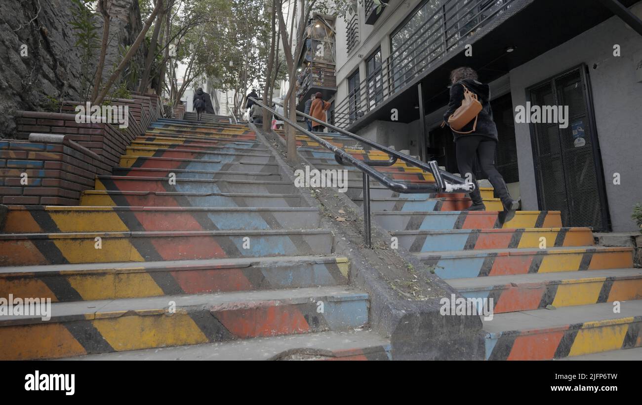 Woman walking up the colorful rainbow stairs. Action. Street outdoors ...