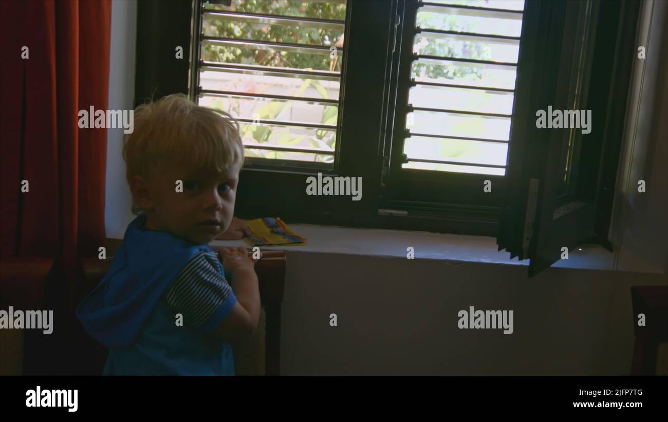 Cute boy looks at camera by window. Creative. Handsome boy looks and ...