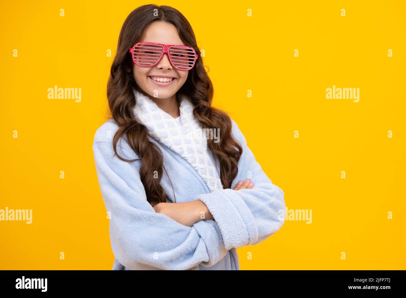 Portrait of teenage girl in funny glasses and pajama or home bathrobe ...