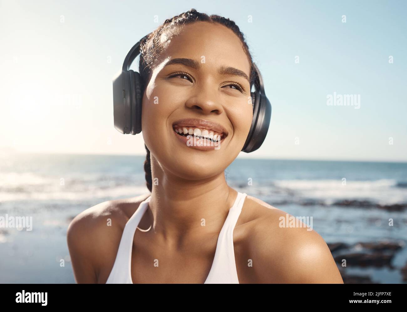 Young mixed race female athlete looking happy and smiling while wearing ...