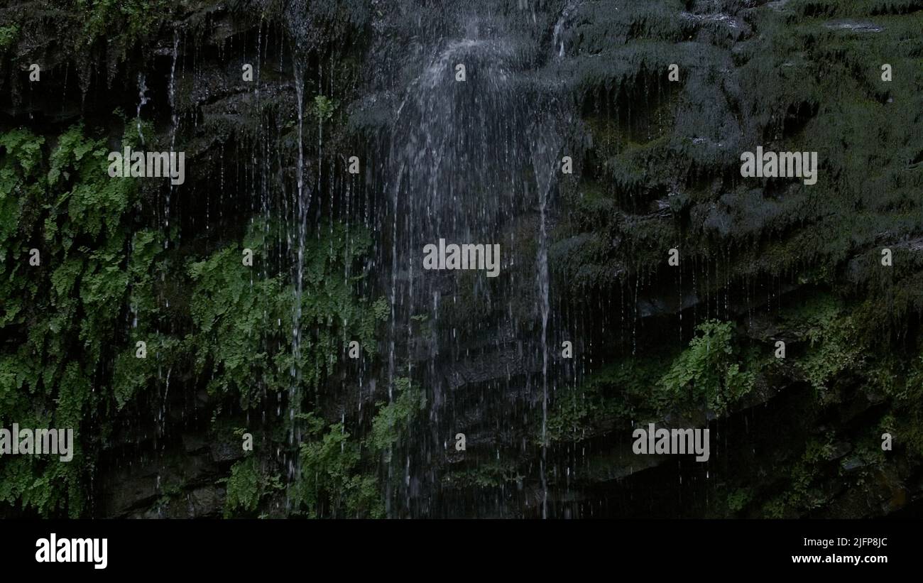 Tiny waterfall running over stones.Creative. Small drops of water ...