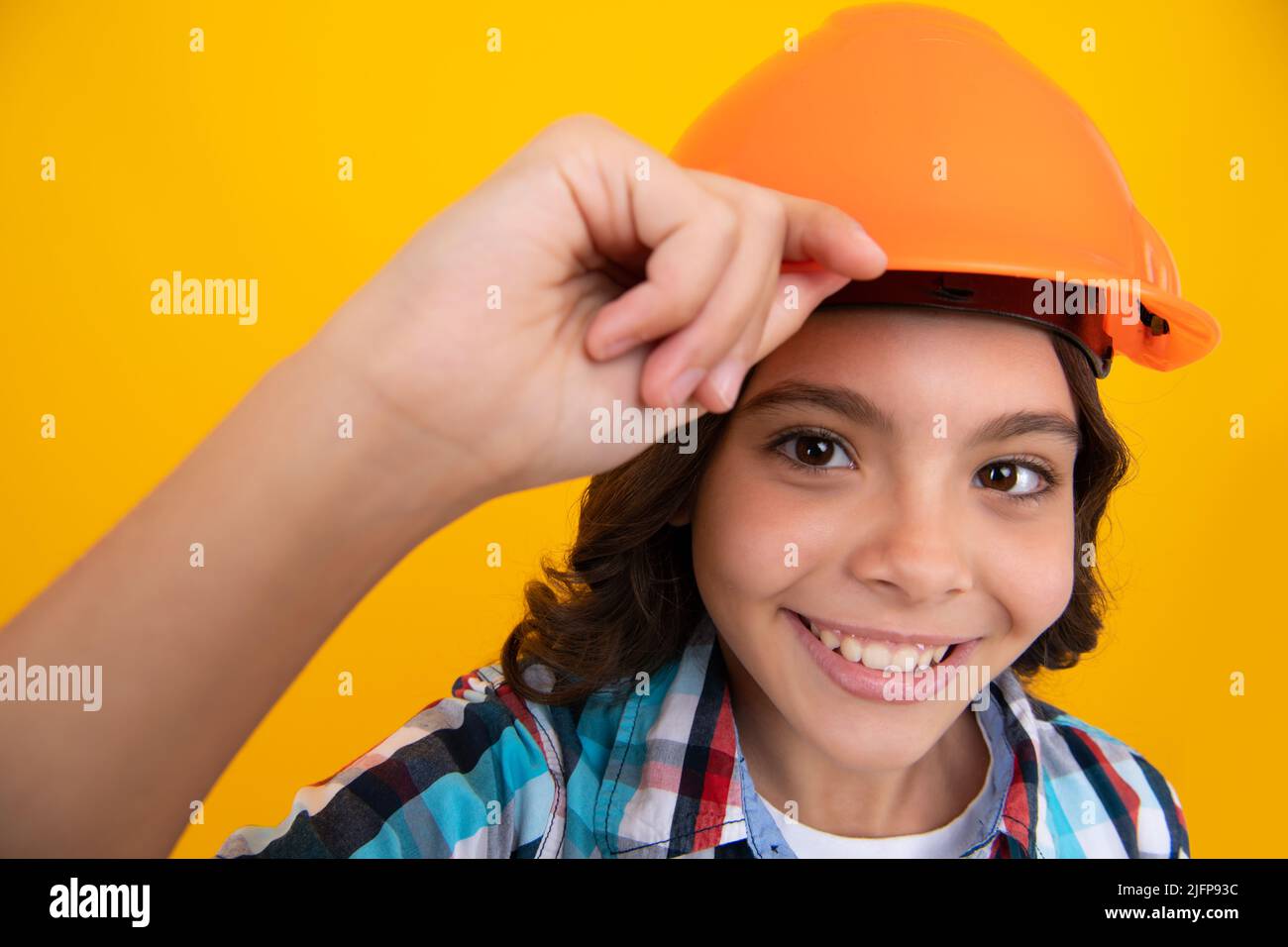 Close up portrait of child builder in helmet. Teenage girl on repairing ...