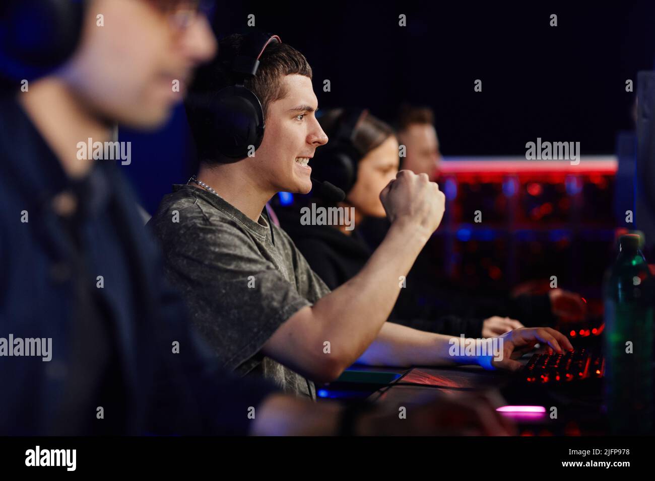 Side view portrait of Caucasian young man playing video game in ...